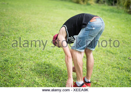 Young man bending down Stock Photo - Alamy