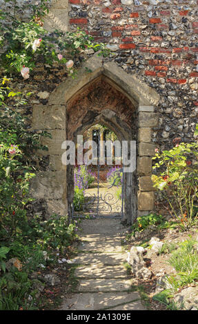 Mittelalterliche Torbogen und schmiedeeisernen Tor in einen Englischen ...