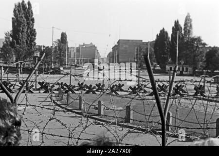 Ein Blick durch Stacheldraht über die Mauer in den Ostteil von Berlin ...