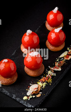 Mini Törtchen aus Beeren verglaste Auf wunderschön auf einer schwarzen ...