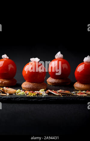 Mini Törtchen aus Beeren verglaste Auf wunderschön auf einer schwarzen ...