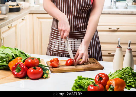 Junge Frau Kochen in der Küche. Hausfrau bereitet Gemüse zum Kochen ...