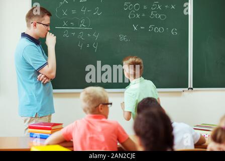 Kinder mit Mathematiklehrer während des Unterrichts im Klassenzimmer ...