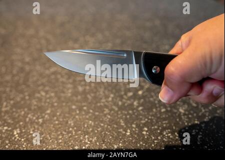 Symbole, Symbolbild, Eine Faust haelt ein Messer in der Hand ...