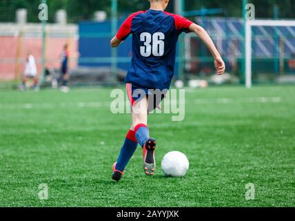 Kinder spielen auf dem Stadionfeld im Freien Fußball. Kinder erzielen ...