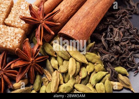 Ganze Kardamom-Körner, ein Stock Zimt-Sternanis und Rohrzucker ...