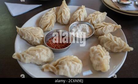 Ein Gericht des tibetisch gekochten momo mit einer Sauce. Momo ist ein ...