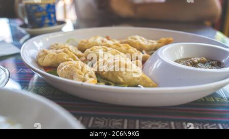 Ein Gericht des tibetisch gebratenen momo mit einer Sauce. Momo ist ein ...