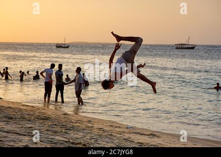 Kinder machen Gymnastik am Strand in Stone Town, abends und morgens ...