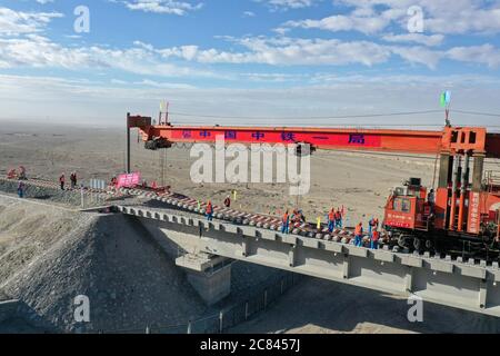 Ruoqiang, China. Juli 2020. Arbeiter legen Gleise auf der Golmud-Korla ...