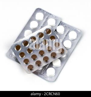 Zwei runde und weiße Tabletten oder Pillen und Tablettenstreifen auf ...
