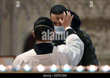 Ein Seminarist legt Asche auf die Stirn eines Kirchenbesuchers in der ...