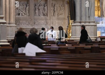 Ein Seminarist legt Asche auf die Stirn eines Kirchenbesuchers in der ...