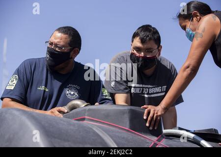 Von links: Jeremy Begay, Eric Teller und Deborah Tso füllen einen Tank ...