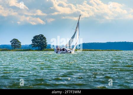 Segelyacht im See mit düsterem Himmel vor dem Regen. Yacht segelt auf ...