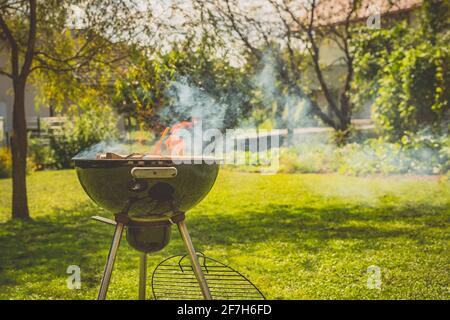 Runder mobiler Grill oder Grill auf einer grünen Fläche oder Rasen ...