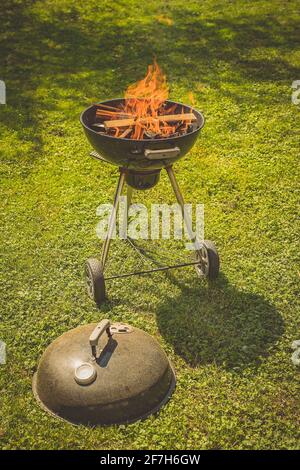 Runder mobiler Grill oder Grill auf einer grünen Fläche oder Rasen ...