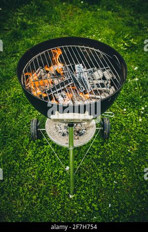 Runder mobiler Grill oder Grill auf einer grünen Fläche oder Rasen ...