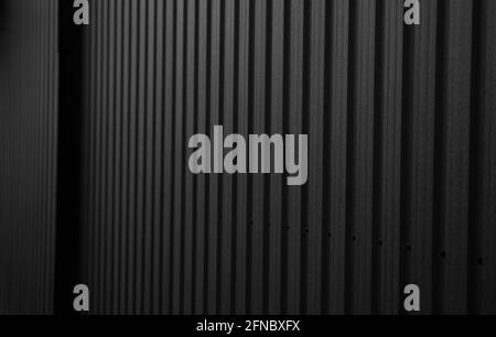 Schwarzes Wellblech, das als Fassade eines Lagers oder einer Fabrik ...