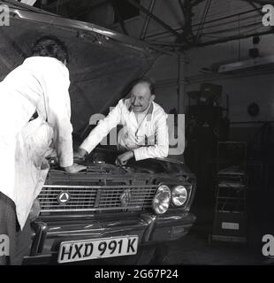 1970s, historisch, in einer Autowerkstatt, zwei Garagenmechaniker, die ...