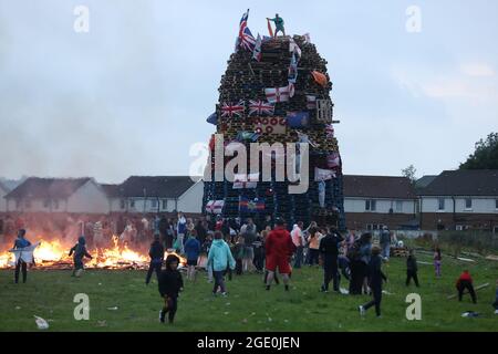 Fahnen und Banner hängen an einem großen Lagerfeuer, das anlässlich des ...