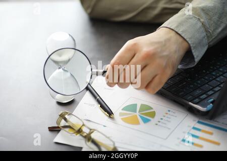 Arbeitszeit symbolisiert eine Sanduhr. Schreibtisch mit ...
