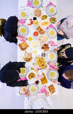 Die muslimische Familie Eid Mubarak isst zu Hause in Iftar zu Abend und macht Fotos mit dem ...