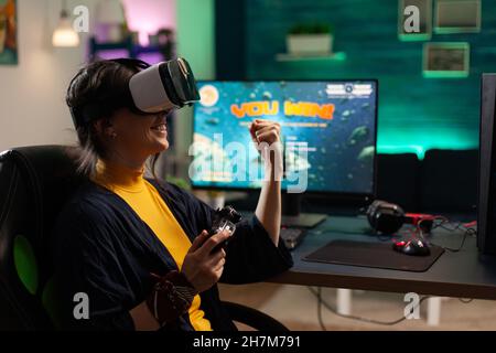 Gamer mit VR Brille und Controller um Videospiele zu spielen. Mann mit Virtual Reality Brille die Joystick vor dem Computer halt und Online Spiel spielt. Spieler der SpaB mit Spielen hat Stockfotograf...