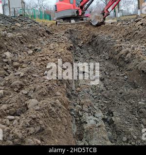 Ein Bagger gräbt einen Graben für Abwasser und Regenwasser am ...