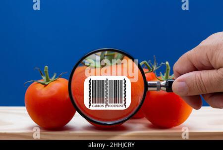 Barcode-Etikett zur CO2-Bilanz auf dem Apfel, vergrößert durch Lupe ...