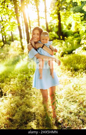Überglücklich Mutter spielen mit entzückenden Tochter im Park, hübsche ...