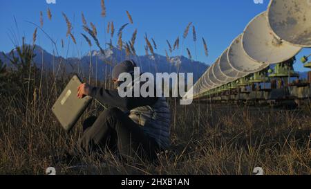 Hacker hackt das Radioteleskop mit einem Notebook. Mann zu ...