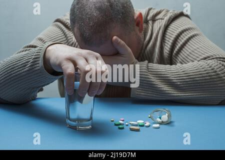 Der Mann versteckt sein Gesicht mit den Händen, die Geste symbolisiert ...