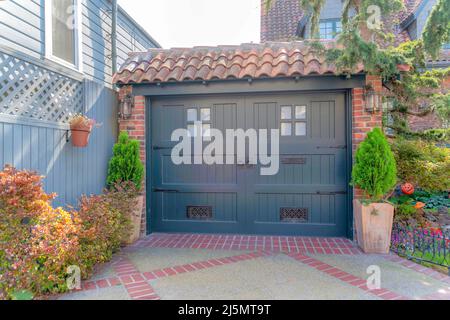 Schwarzes, seitlich aufklappbares Garagentor im französischen ...