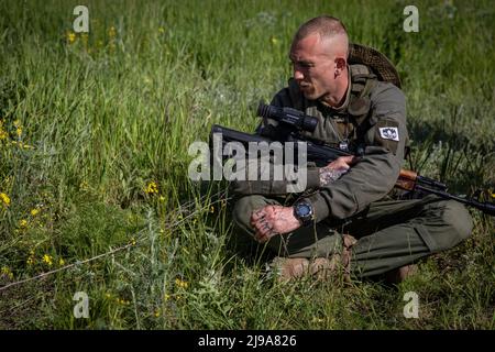 Donezk, Ukraine. 20.. Mai 2022. Ein ukrainischer Soldat beobachtet eine nicht explodierte ...