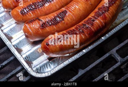Gegrillte Wurst auf einem Aluminiumkissen. Grill, Zubereitung von ...