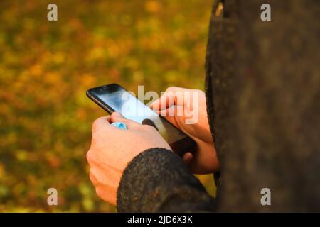 Unschärfe-Effekt bei männlicher Hand, die das Telefon hält. Mann, der ...