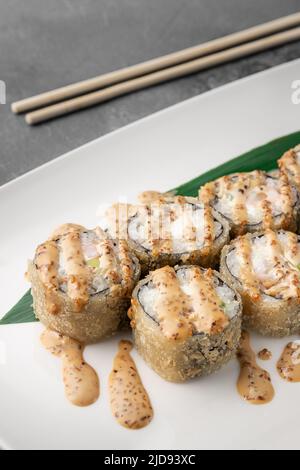 Set aus frittierten Rollen mit Tiger Shrimp, Avocado, Sesamsauce und ...