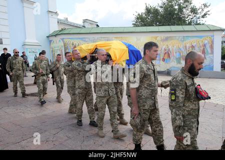 KIEW, UKRAINE - 18. JULI 2022 - Soldaten tragen den Sarg, der mit einer ...