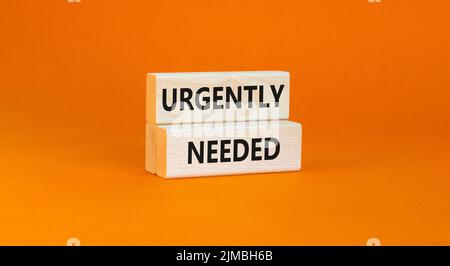 Dringend benötigtes Symbol. Konzeptwörter, die dringend auf Holzblöcken ...