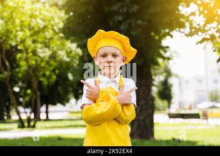 Zeigt richtig. Schöner Koch Kind in gelben Köchhut und Schürze gelbe ...