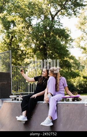 Handy-süchtig Sportkinder mit Skateboard und Penny Boards verwenden ...