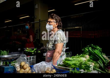 Die Menschen kommen mit Masken und respektieren die Distanz, kaufen auf ...