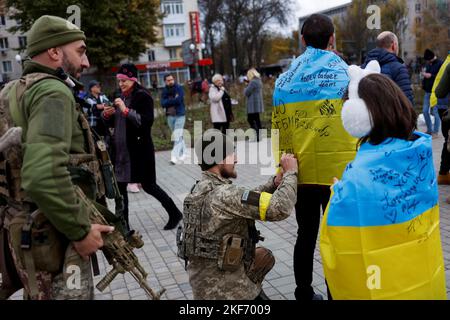 Ein ukrainischer Militärangehöriger gibt einem Bewohner im Zentrum von Cherson ein Autogramm ...