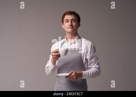 Ein positiver männlicher Kellner schaut direkt in die Kamera. Der ...