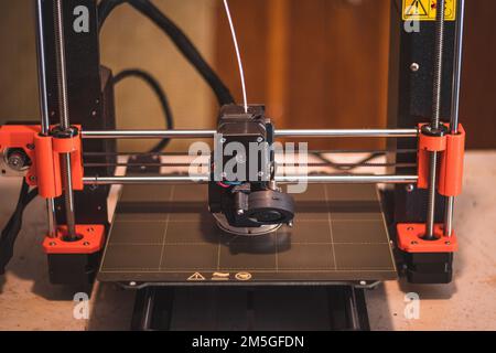 Technologisches Hi-teg-Tool für neue Dinge. Ein schwarz-roter 3D-Drucker bei der Arbeit. Das ...