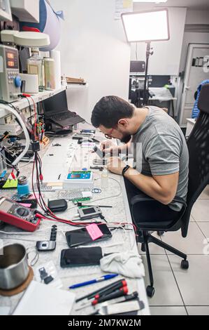 Elektronik-Reparaturwerkstatt, ein Techniker ist von Werkzeugen und ...