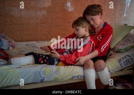 Natasha Stepanenko, 43, sits on her bed with her daughter Yana, 11, at ...