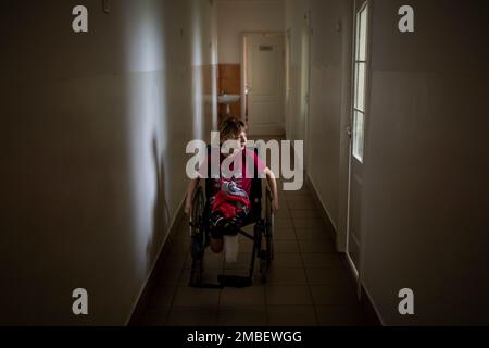 Yana Stepanenko, 11, sits next to the window on her wheelchair at a ...