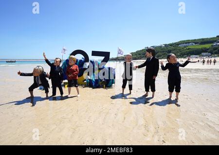 Protestors wear giant heads portraying the leaders of the G7 as they ...